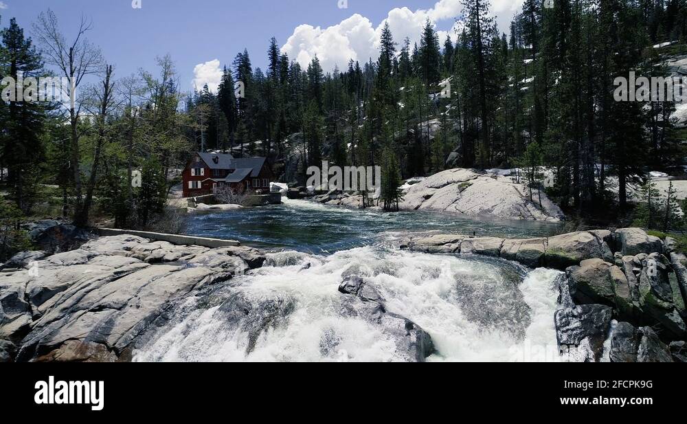 Dolly forward revealing river, waterfall and red house by river Stock ...