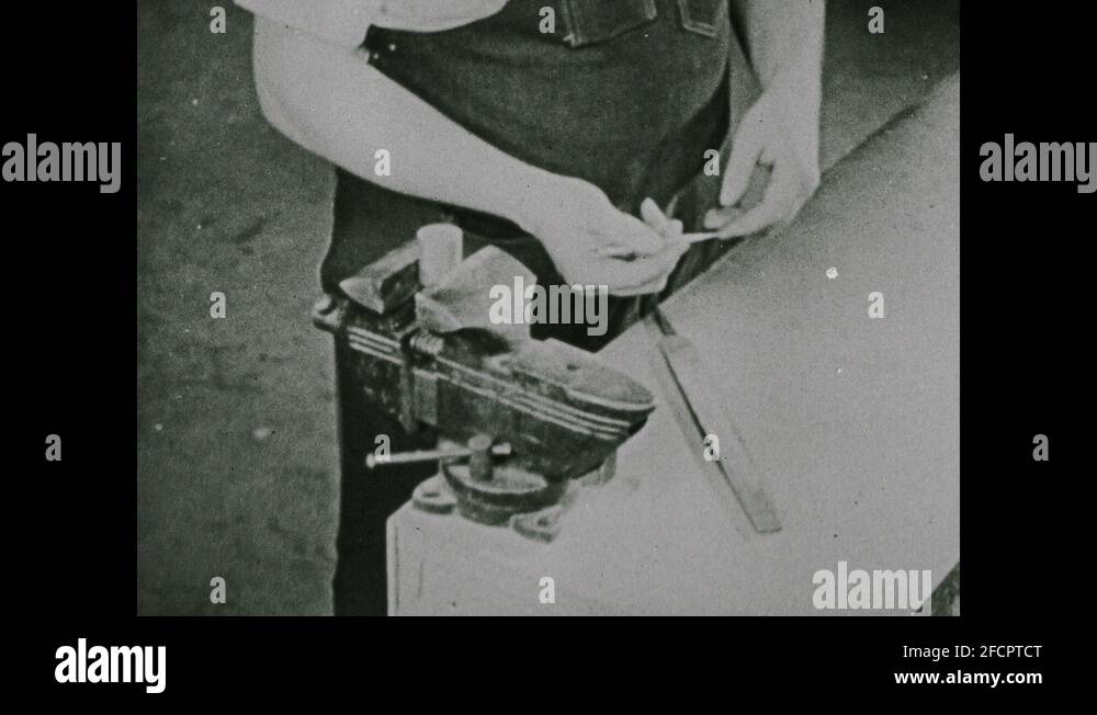 1940s: UNITED STATES: hand file on table. Man uses file card to clean ...