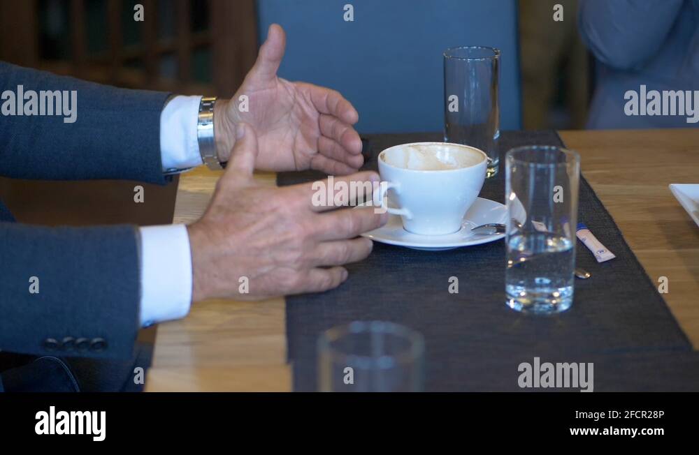 Businessman expressing ideas with hand gestures on a meeting table ...