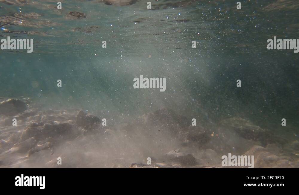 Underwater sun rays hitting lake bottom, rock falling on floor Stock ...