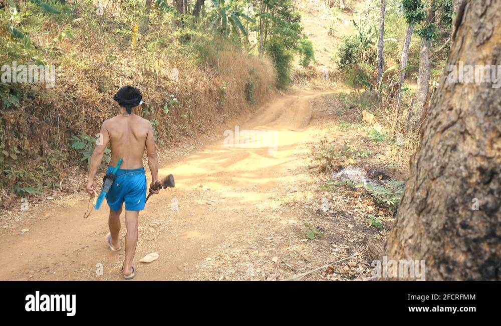 Asian Male Guide with Large Musket, Knife and Slingshot Walking on a ...