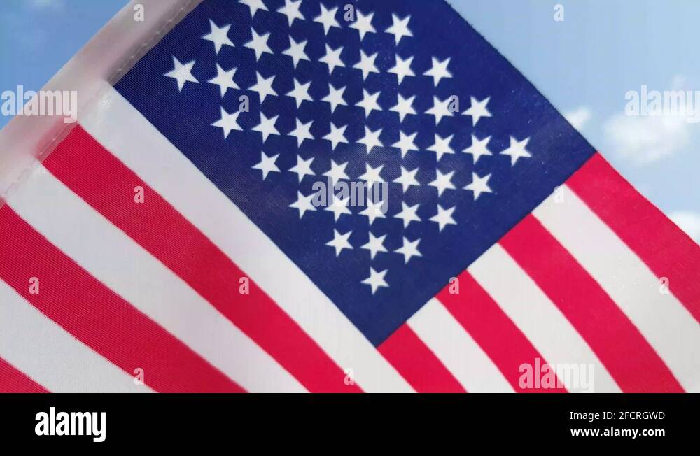 USA flag fluttering on the wind against bright blue sky with fluffy ...