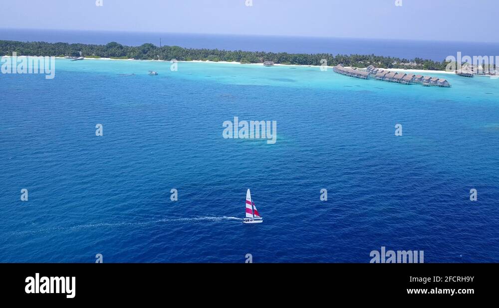 Sailing boat takes a short tour around beautiful shore of tropical ...