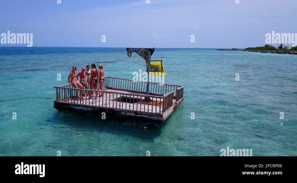 People standing on floating raft, women tanning in bikini, ocean lagoon ...