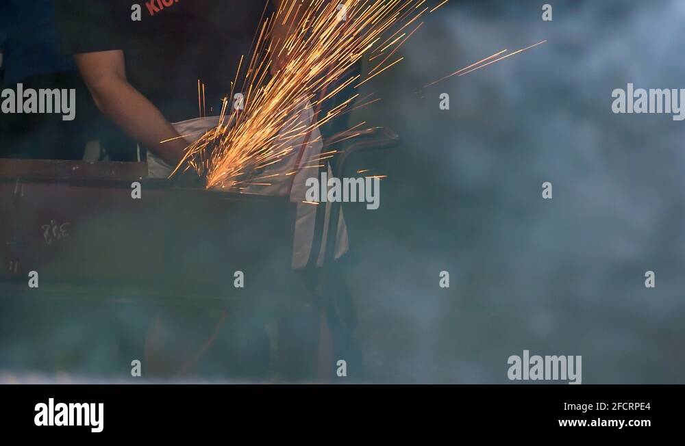Adult Male Using Metal Grinder With Sparks Flying Off Surrounded By ...