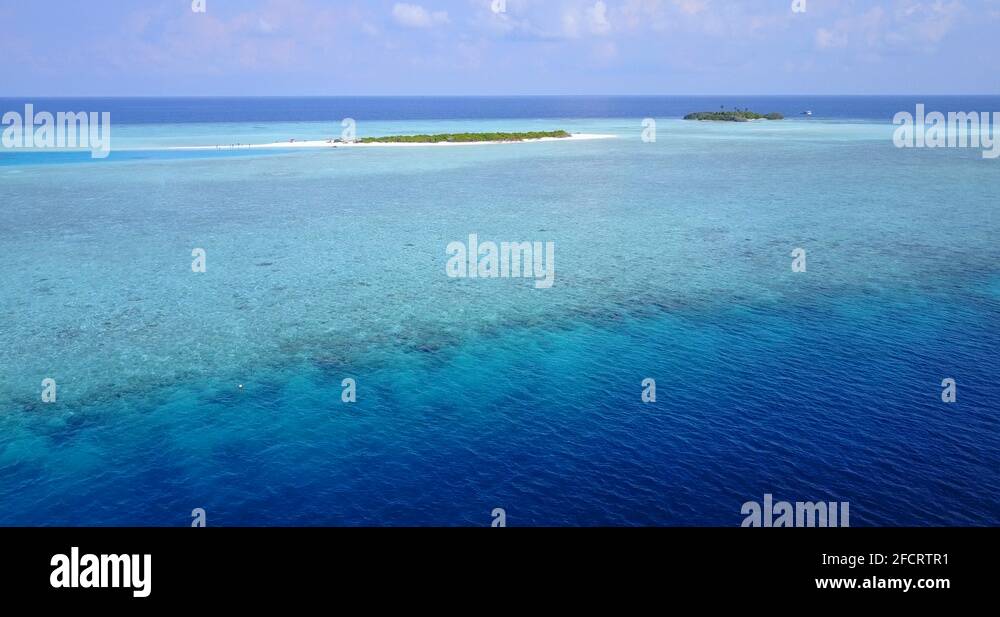 Wide lagoon full of coral reefs thriving on calm warm water surrounding ...