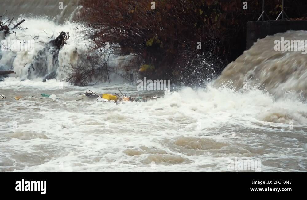Garbage trash floats in circles in violent flood river with washed up ...