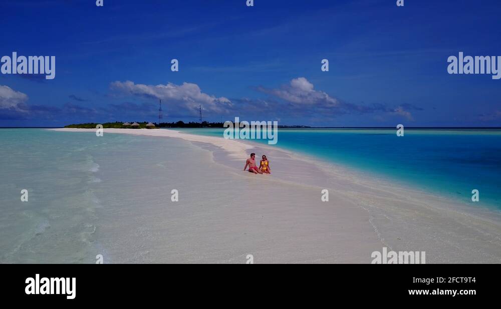 pair on warm vacation beach in bali, couple tanning in their swimwear ...