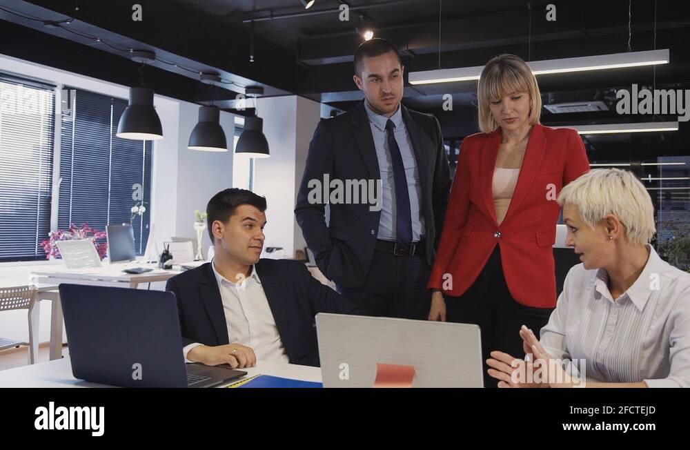 Woman and man sitting behind table with laptop and making brains Stock ...