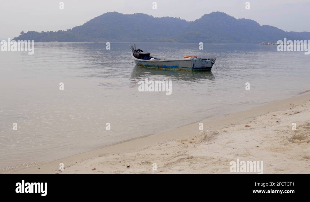 Wooden fishing boat in the Penang Strait with Jerejak Island in the ...