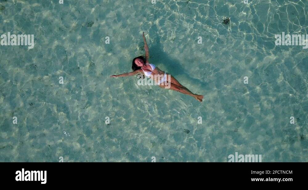 woman in white bikini floating in crystal ocean seawater of bali Stock ...