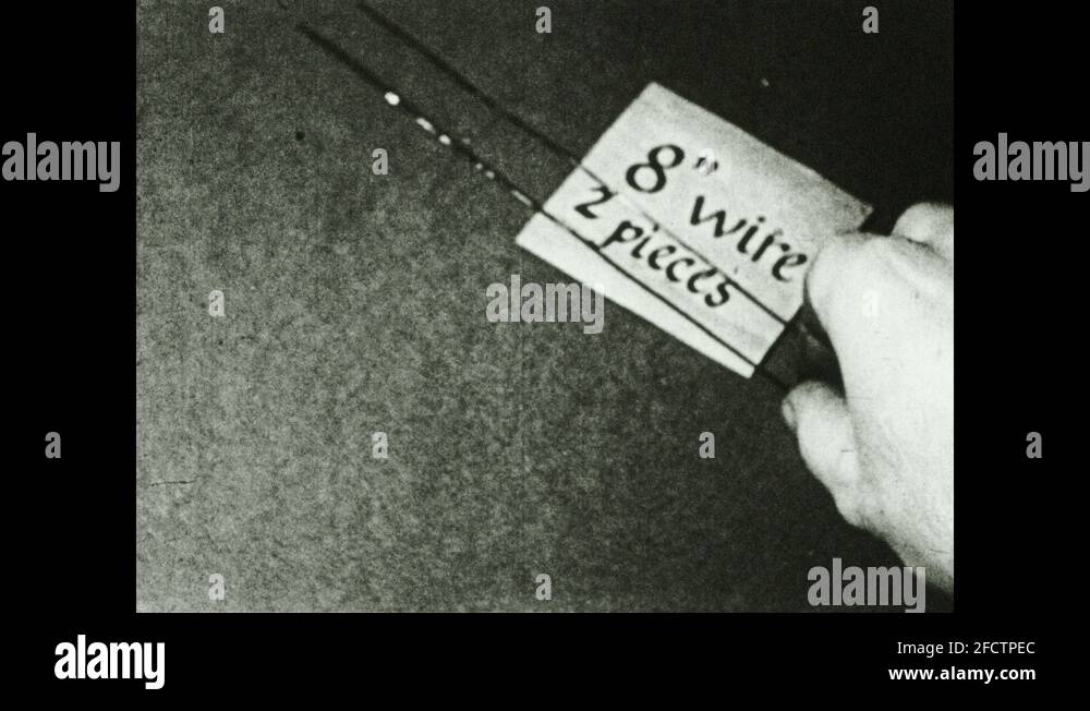 1930s: Hands remove wire from paper with text. Hands fold wire into ...