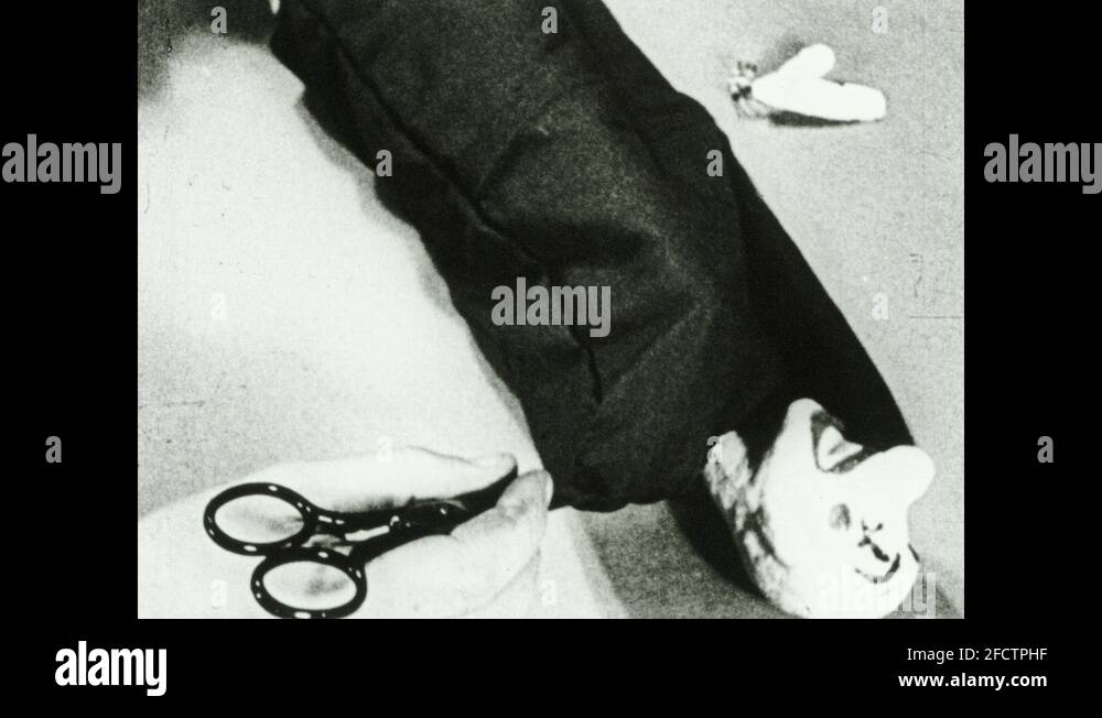 1930s: Man twists wire puppet hands into body of puppet. Man sews ...