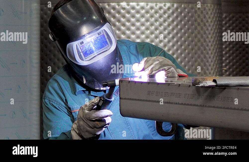 Static shot of worker welding stainless steel part, using TIG, MIG ...