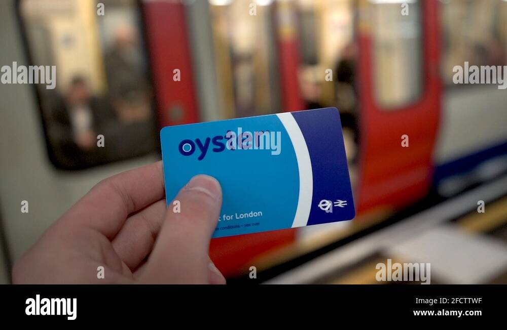 Male hand holding London Oyster card in public transport underground ...