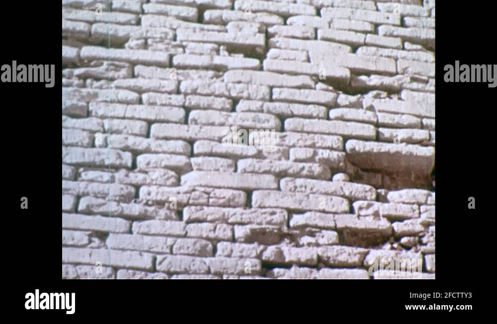 1950s: Field of bricks lined up. Bitumen wells up from pool in ground ...
