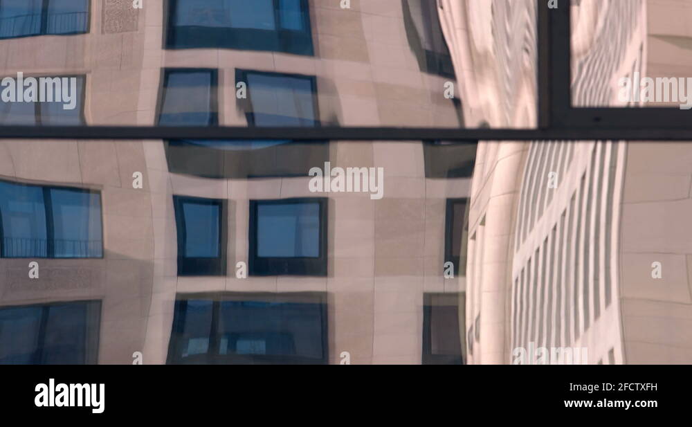 Distorted reflection in the glass of the window of a building standing ...