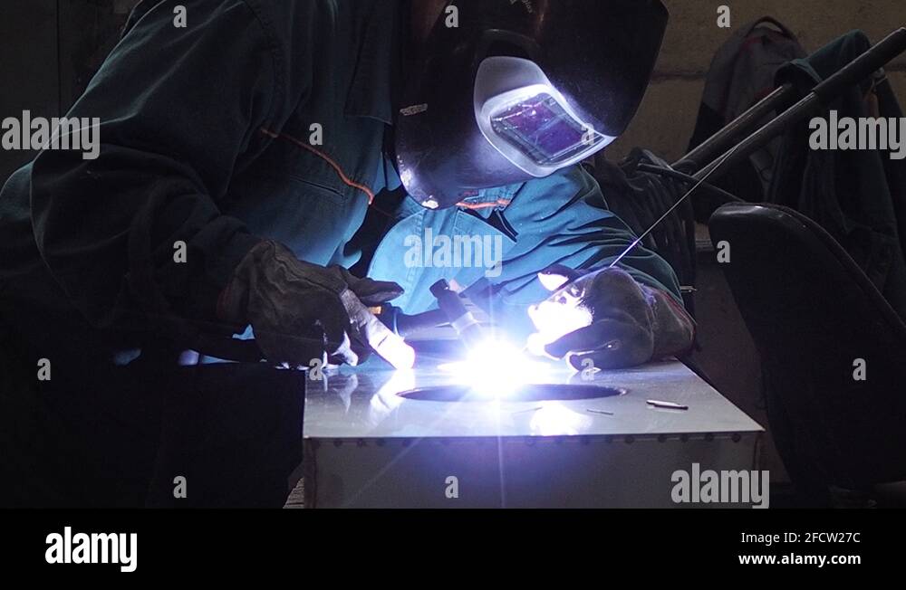 Static shot of worker welding stainless steel part, using TIG, MIG ...