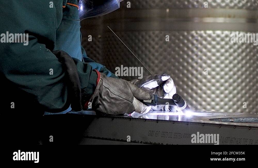 Pan shot, Worker welding stainless steel part, using TIG, MIG, welder ...