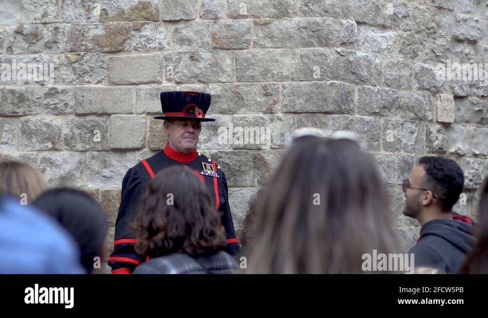 Tourist group listening to british tour guide who is a guard at the ...