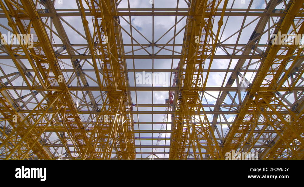 Many large yellow metal beams to help build the roof of the new stadium ...