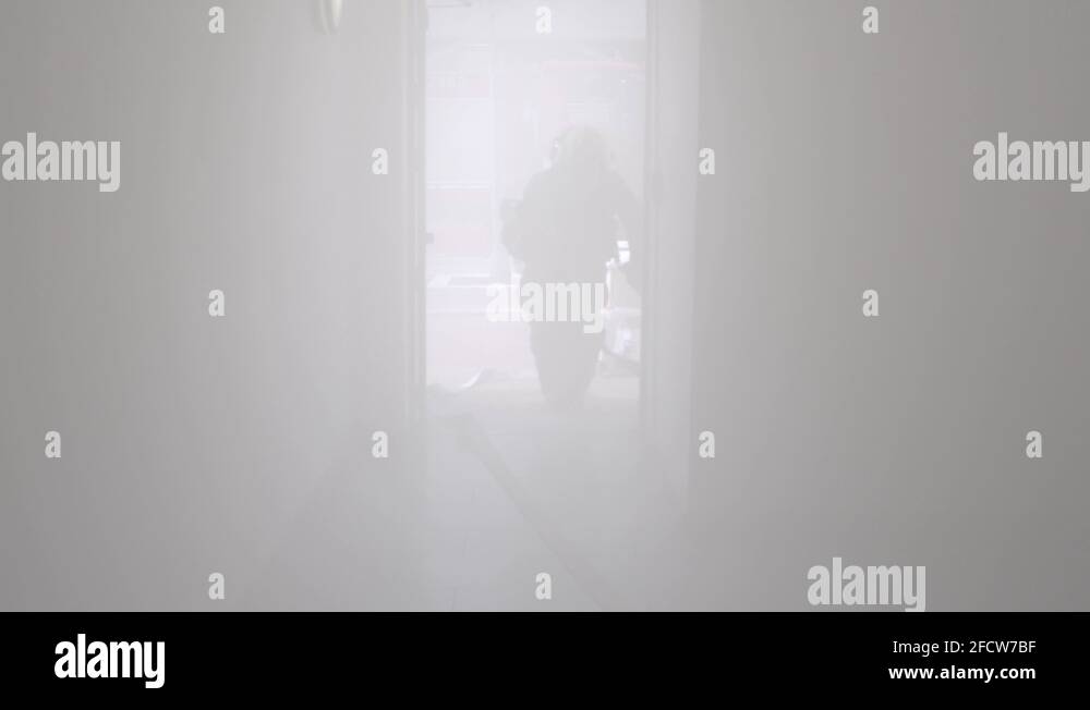 A unique point of view from inside a smoke-filled hallway as a ...