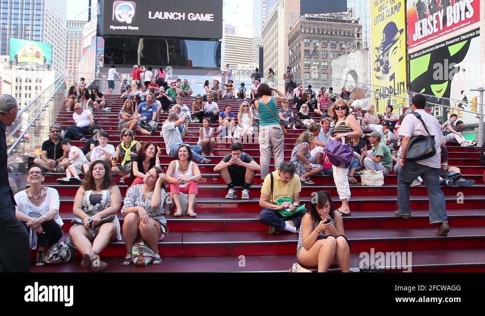 People sitting on the red stepped seating in Times Square Stock Video ...