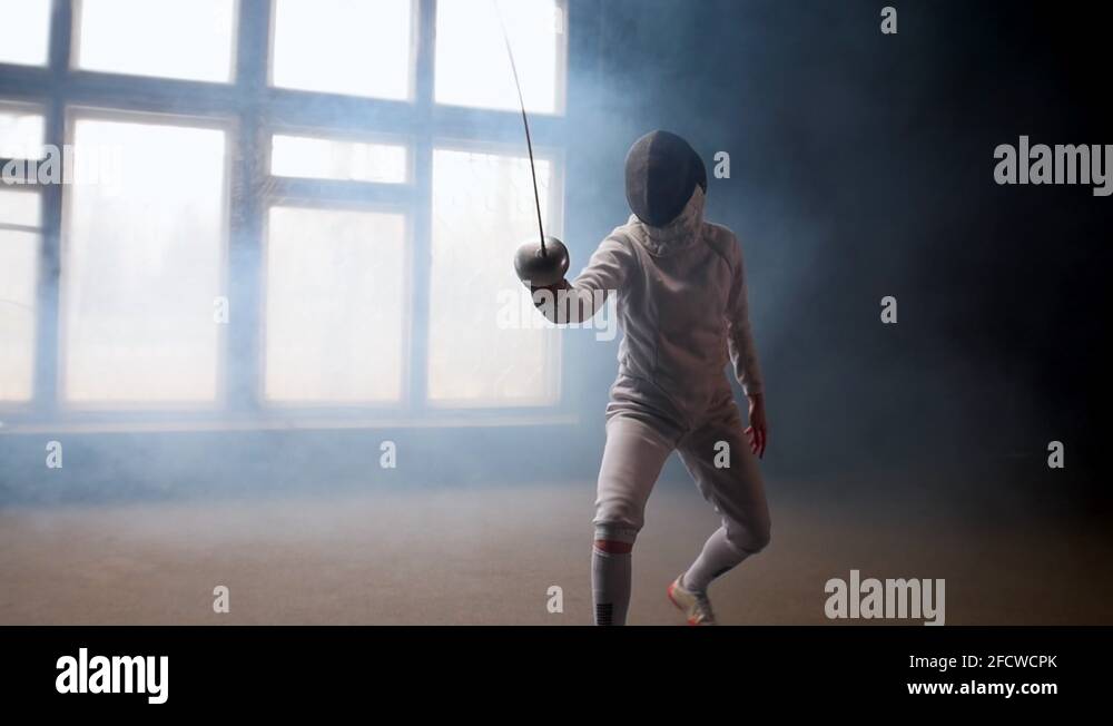 A young woman fencer showing basic attack movements on the fencing ...