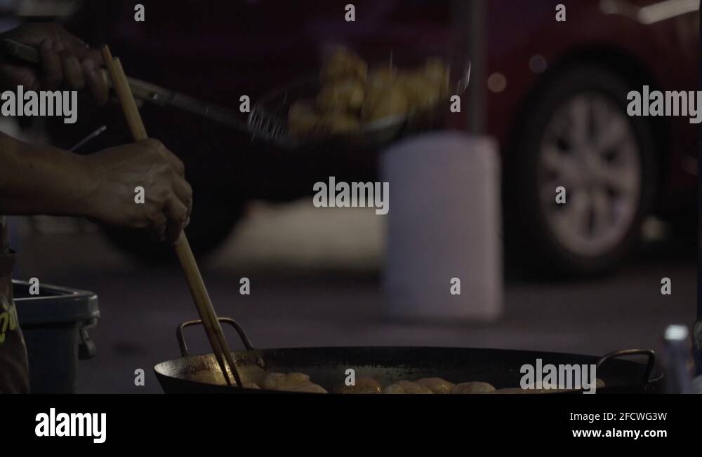 Thai man throwing food in a Wok in food market in Bangkok, Thailand ...