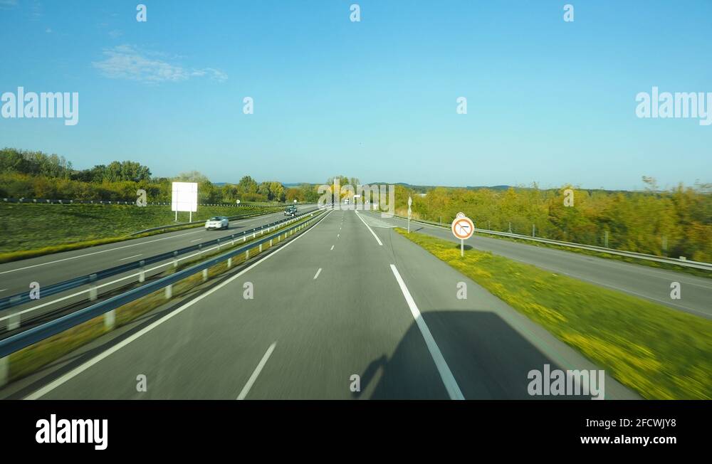 Bus driver point of view. Driving on straight road passing by highway ...
