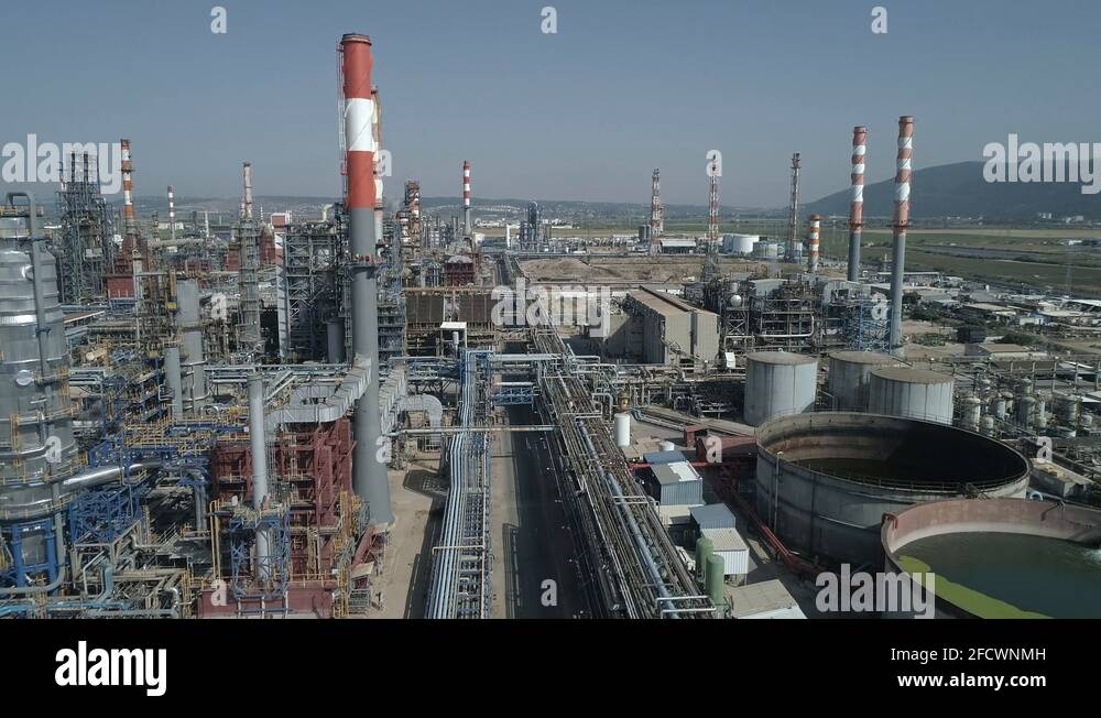 large scale Oil refinery with smoke stacks and petroleum storage tanks ...