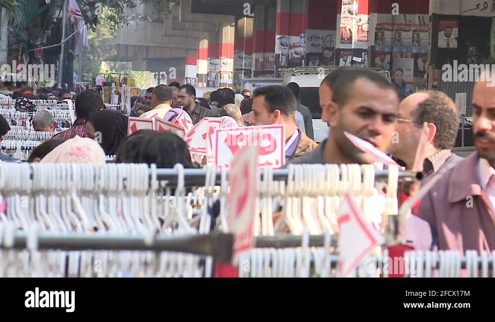 Crowd of people at a busy street in Cairo, street vendors at left ...