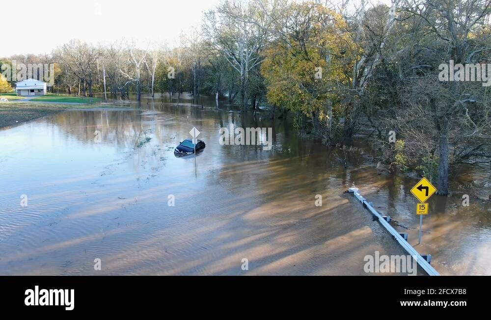 Aerial push in on car stuck in flood water after hurricane-swollen ...