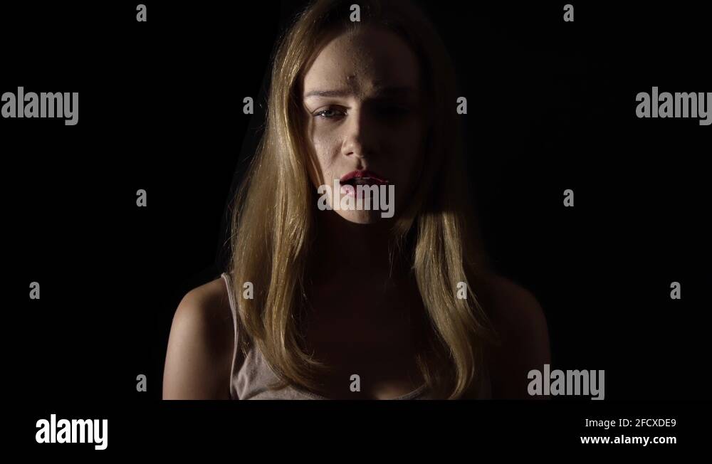 Terrified woman on black background. Scared facial expression in horror ...