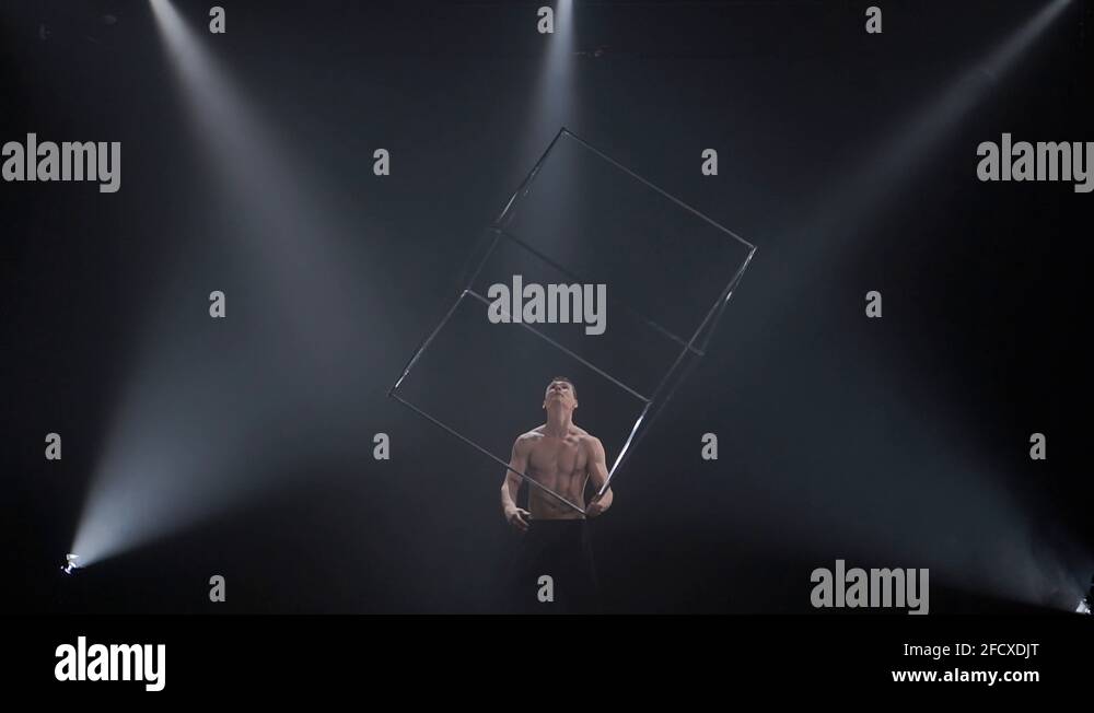 circus male muscular performer making tricks with juggling cube props ...