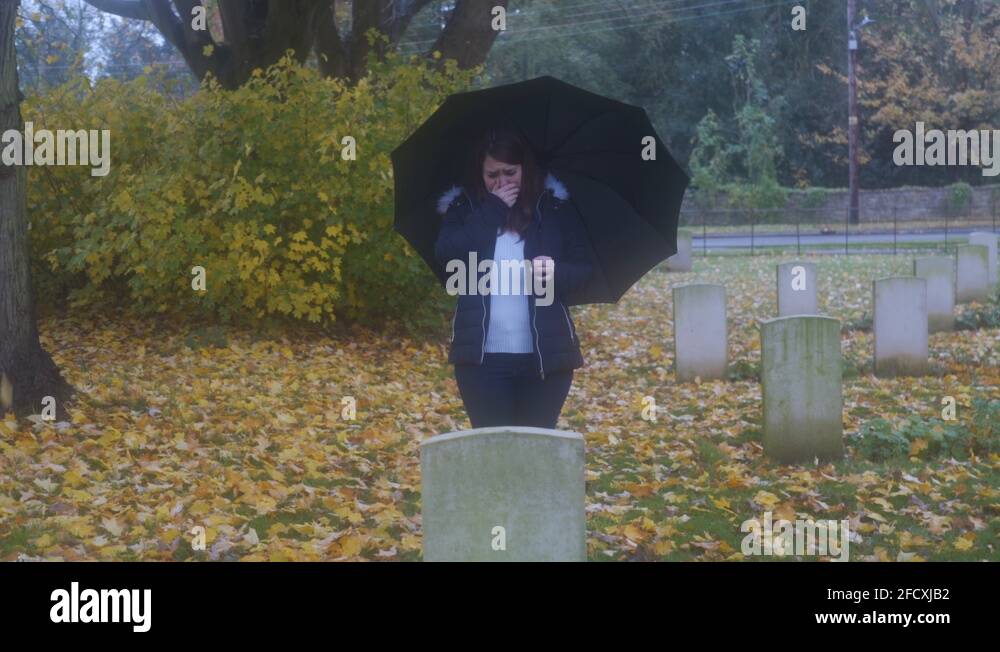 Sad Woman Holding a Black Umbrella Crying in Front of a Tombstone Stock ...