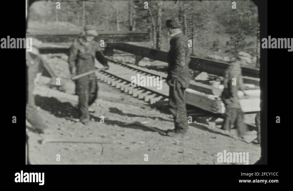 1930s: UNITED STATES: construction workers by railway lines. Men clear ...