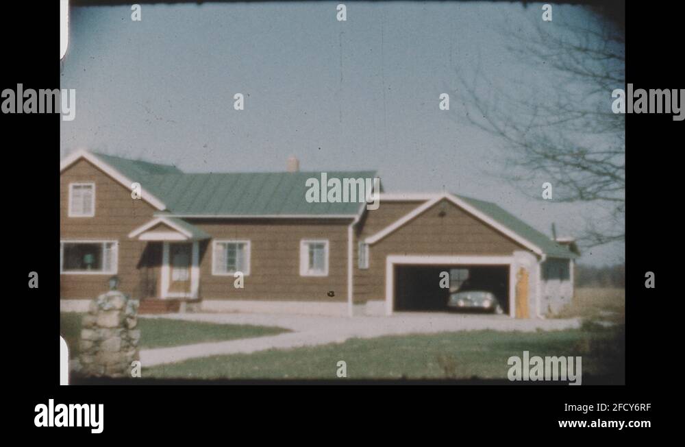 1940s: Home and open garage in rural yard. Driveway leads to open ...