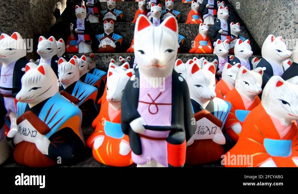 Slow Wide Angle Pedestal shot of small fox statues at Fushimi Inari ...