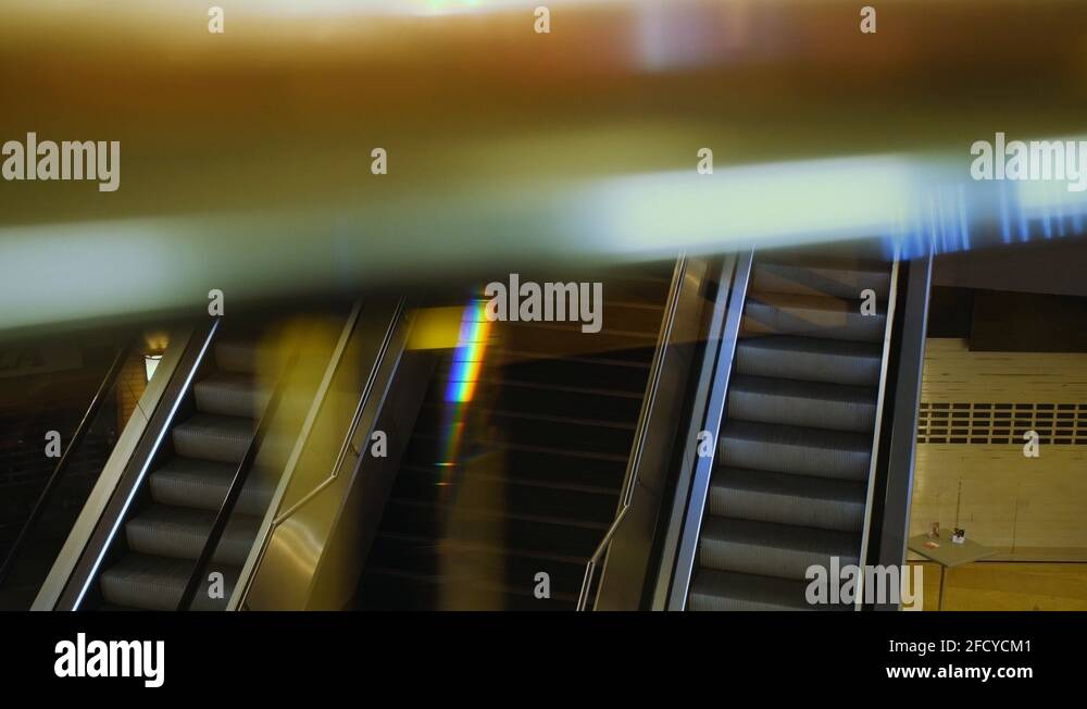 Tilt down shot of two escalators in the middle of a mall at closing ...