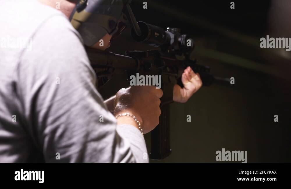 Man firing an assault rifle in a shooting range with the shell jumping ...