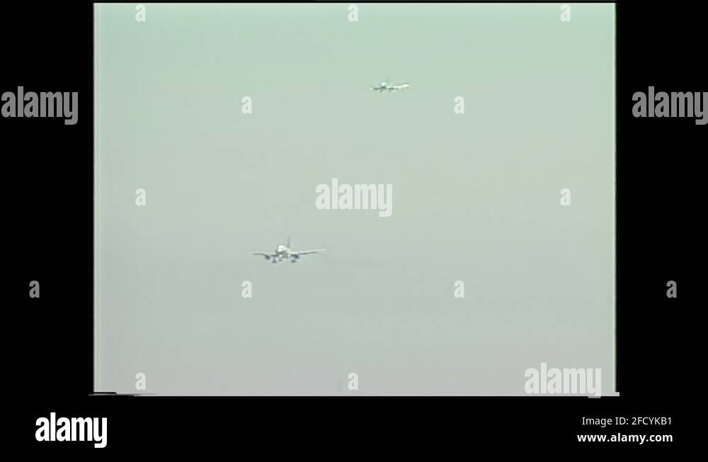 1990s: Airplanes in sky. Men work in air traffic control tower. Pilots ...