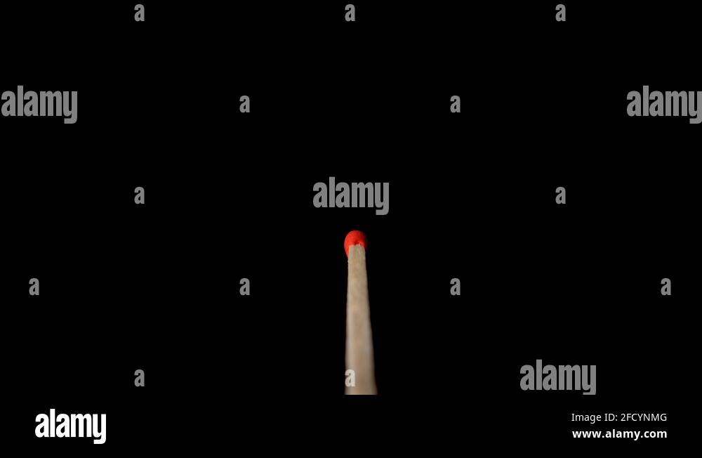 Single match lit on fire with a torch and burning down. Black ...