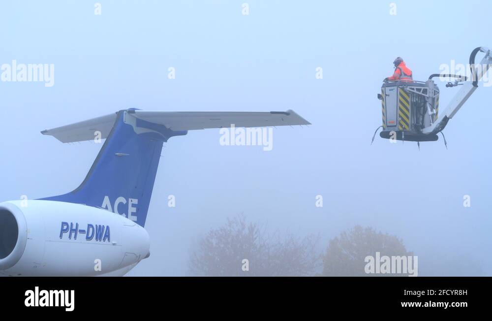 A ground crew handler in an aerial platform maneuvering around an ...