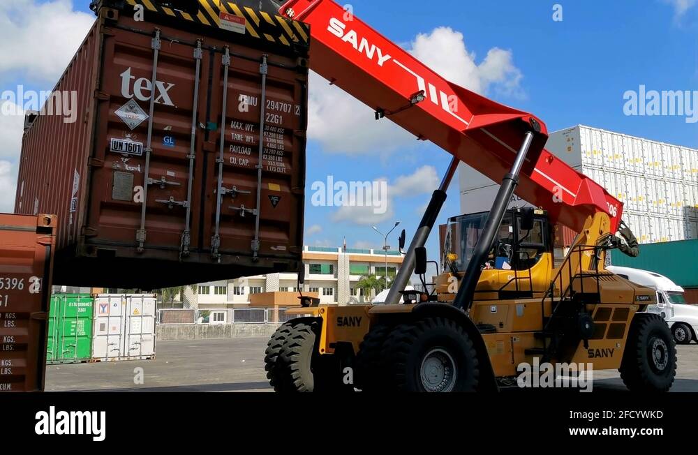 Reach Stacker lifting loaded container in sea port container yard Stock ...