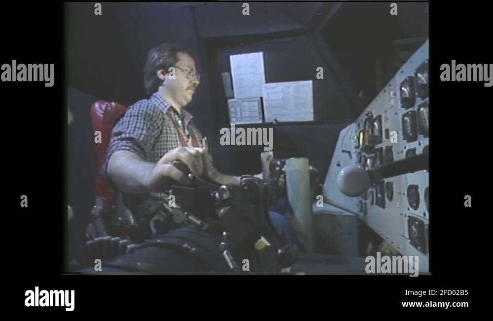 1990s: Man sits in cockpit of flight simulator. Images on screen in ...
