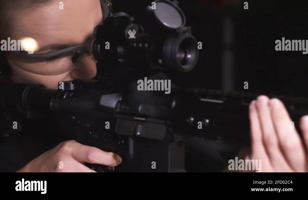 Woman in a shooting range firing an assault rifle in slow motion Stock ...