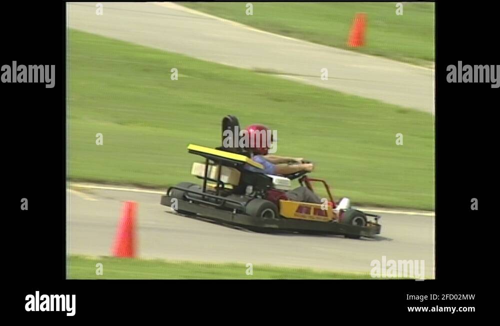 1990s: Boy and girl drive go carts on race track. Animated engine ...