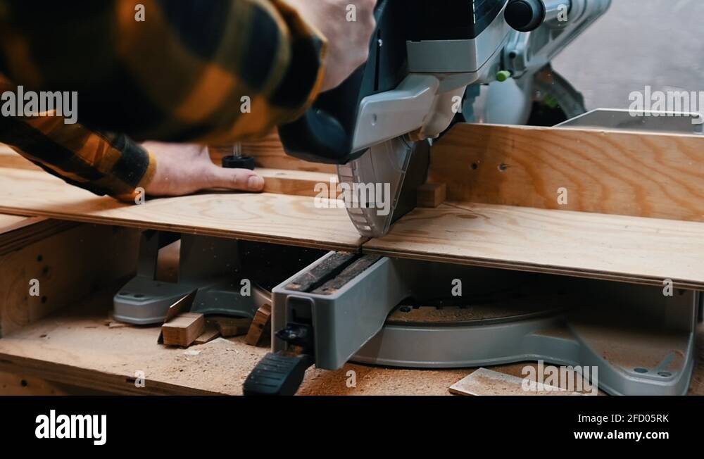Carpentry industry - a woodworker cutting a piece of wood with a big ...