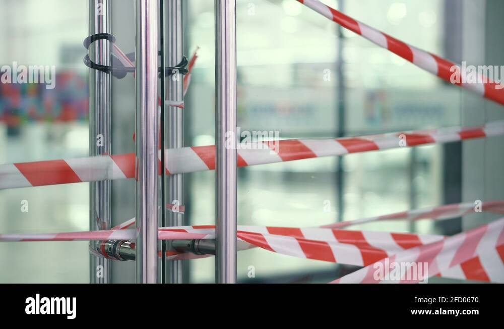 Closed glass door to the mall with a pull-out barrier tape. Closed ...